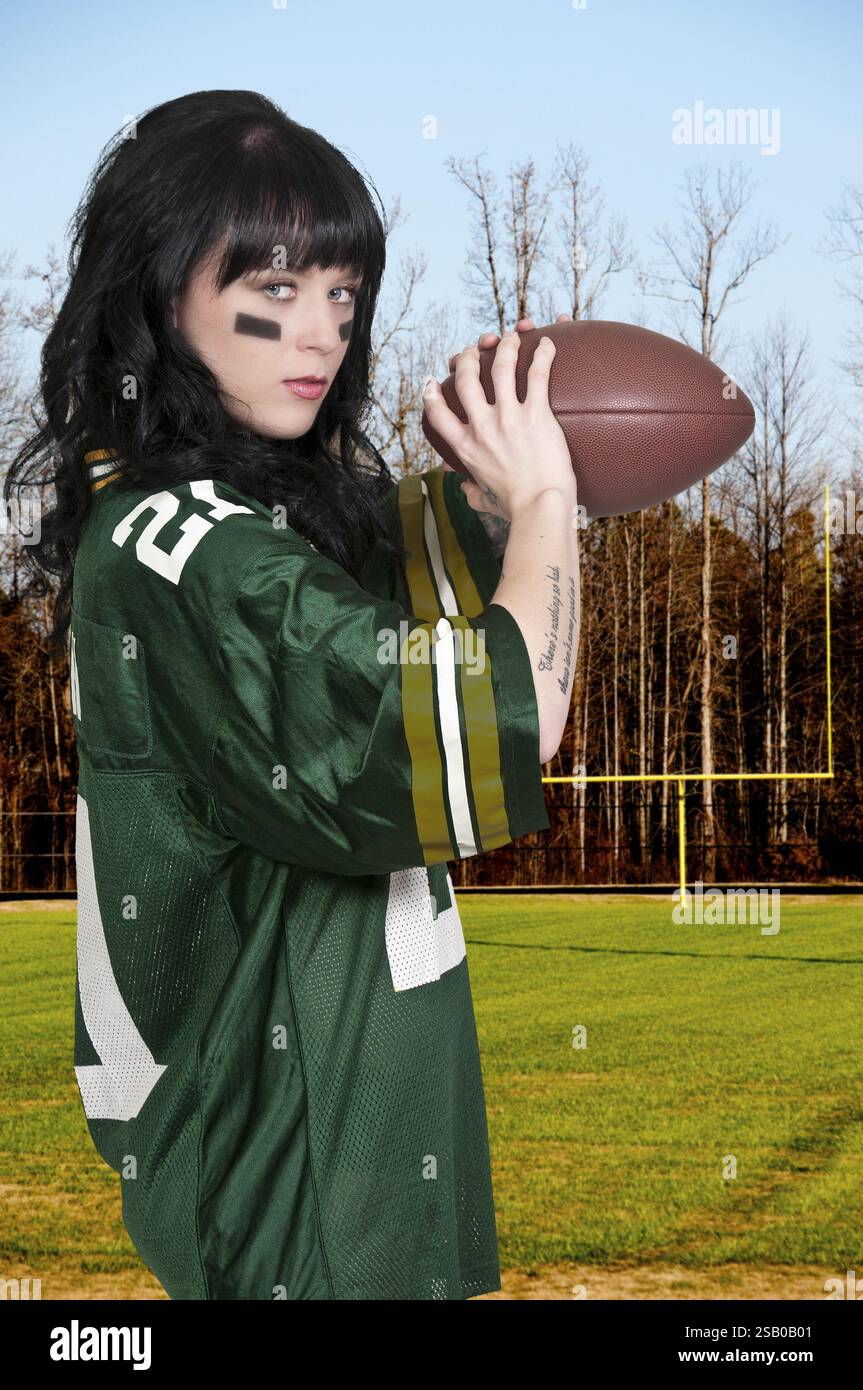 Beautiful young woman playing a game of football Stock Photo - Alamy