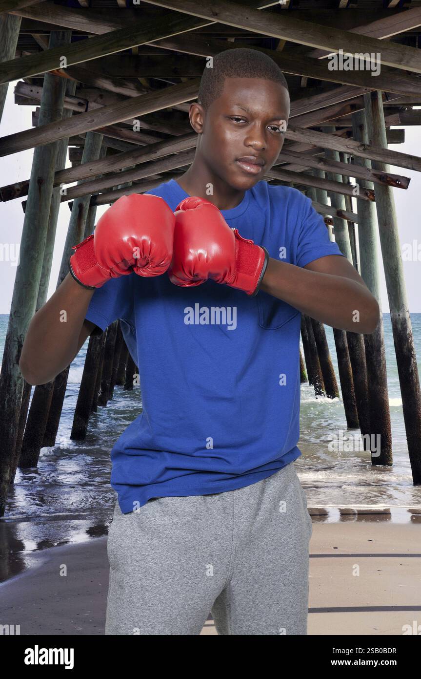 Black African American teenage boy athletic boxer with boxing gloves ...