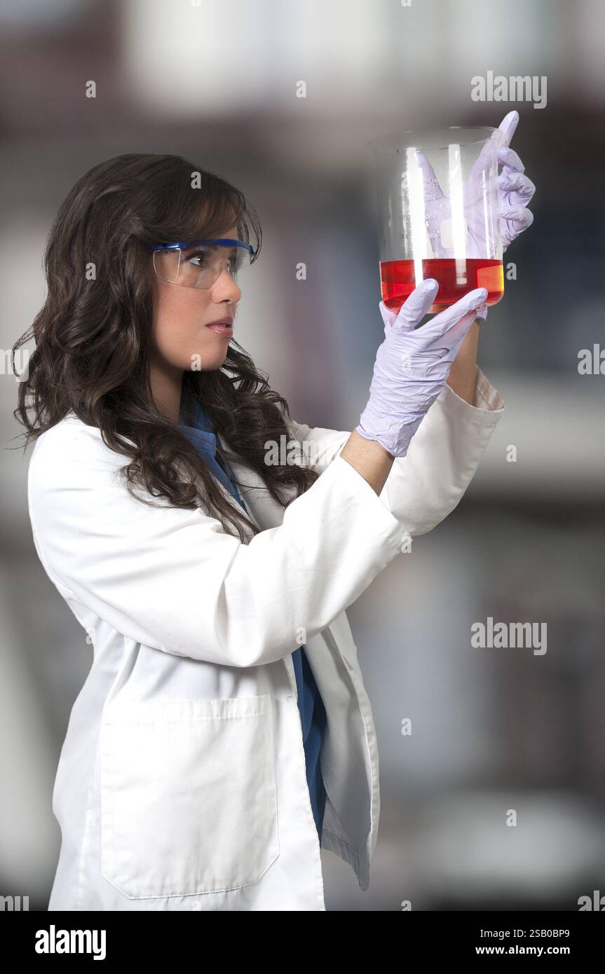 Beautiful woman scientist investigating a glass beaker Stock Photo - Alamy