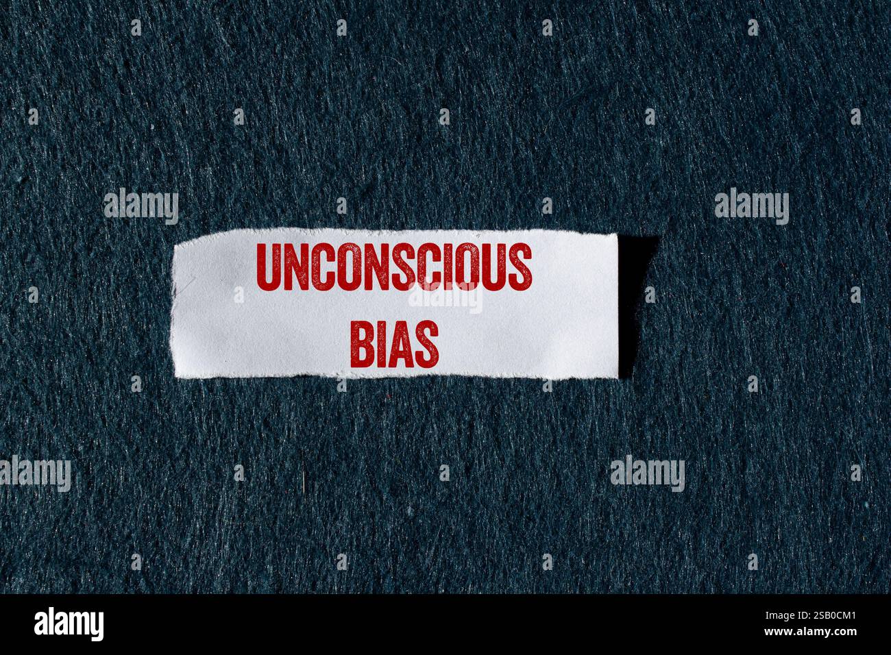 Unconscious bias message written on ripped torn paper piece with gray background. Conceptual ...