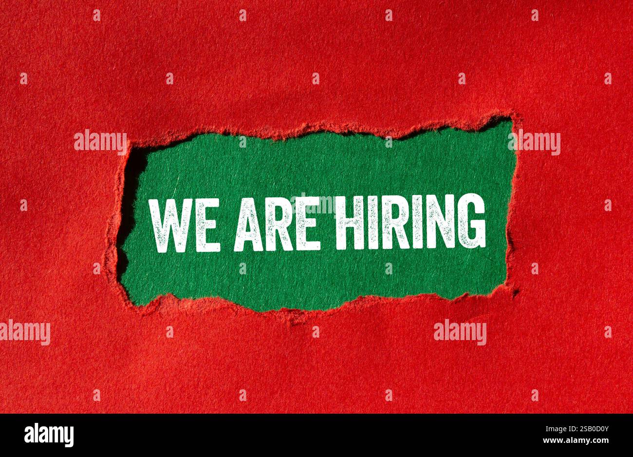 We are hiring message written on ripped torn red paper on green background. Conceptual we are ...