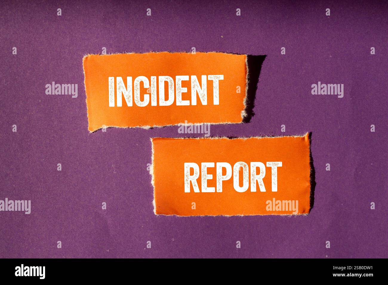 Incident report message written on ripped torn orange paper pieces on purple background ...