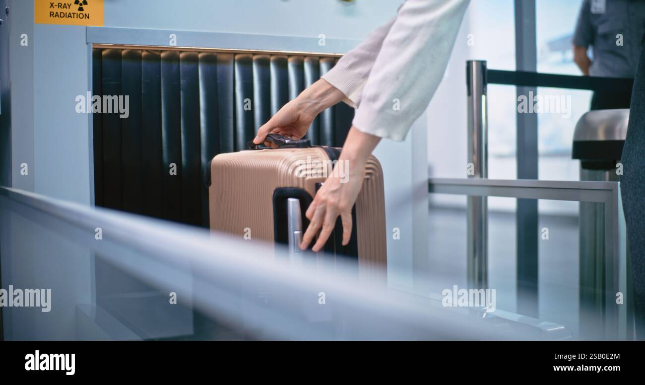 Security Checkpoint in Airport Terminal: Passenger Places Suitcase on ...