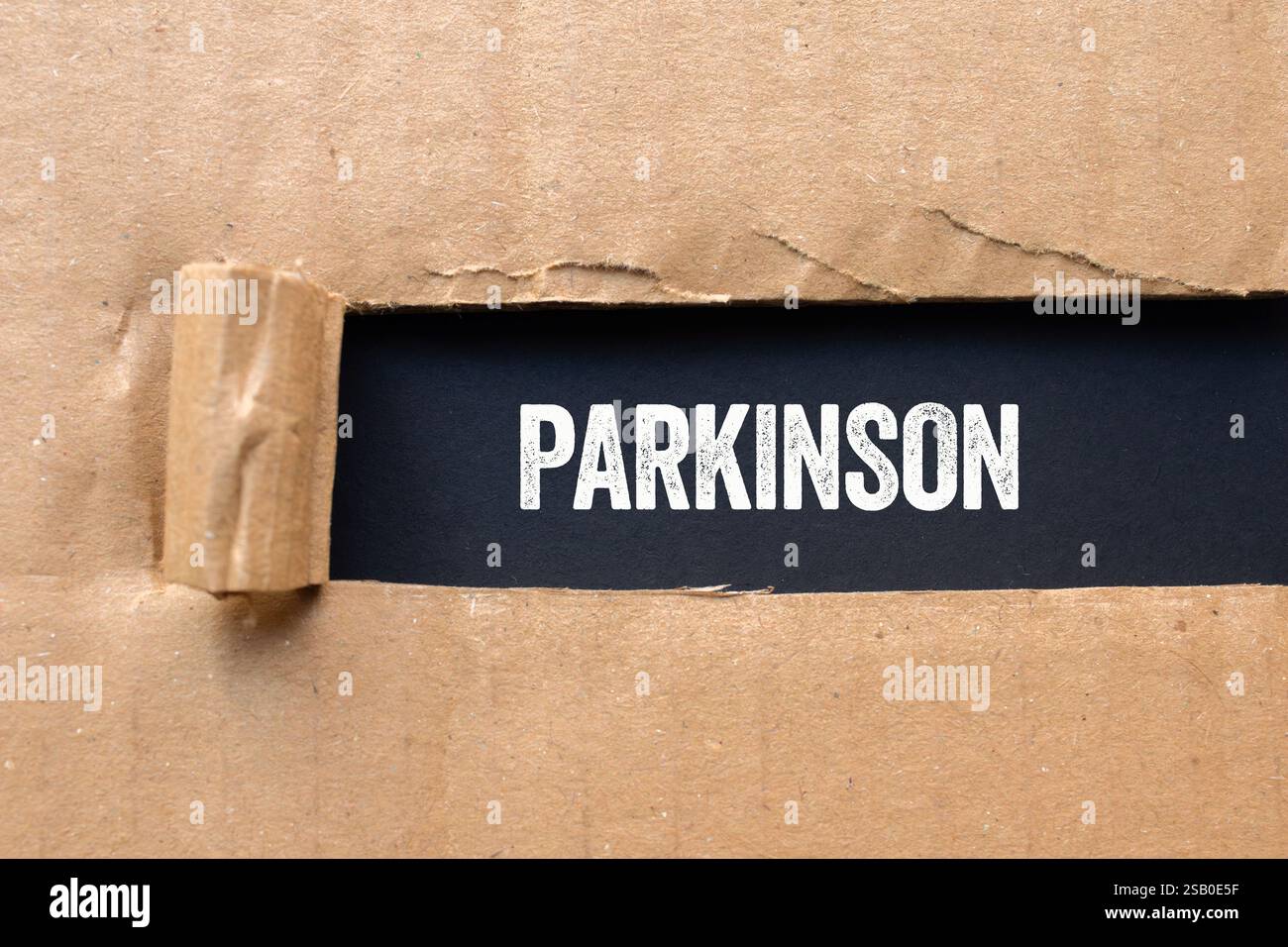 Parkinson message written on ripped torn cardboard paper on black background. Conceptual ...