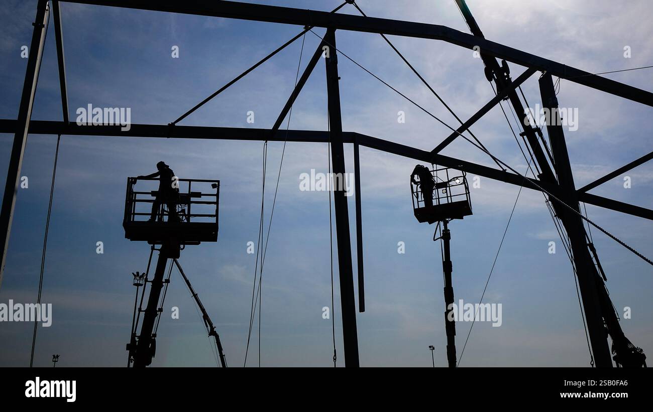 Man workers on a crane performs high-rise work on welding metal ...