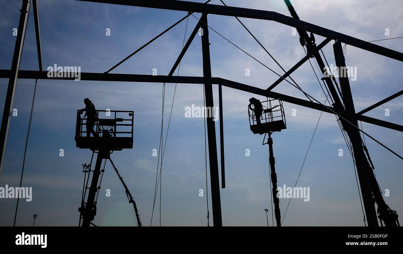 Man workers on a crane performs high-rise work on welding metal ...