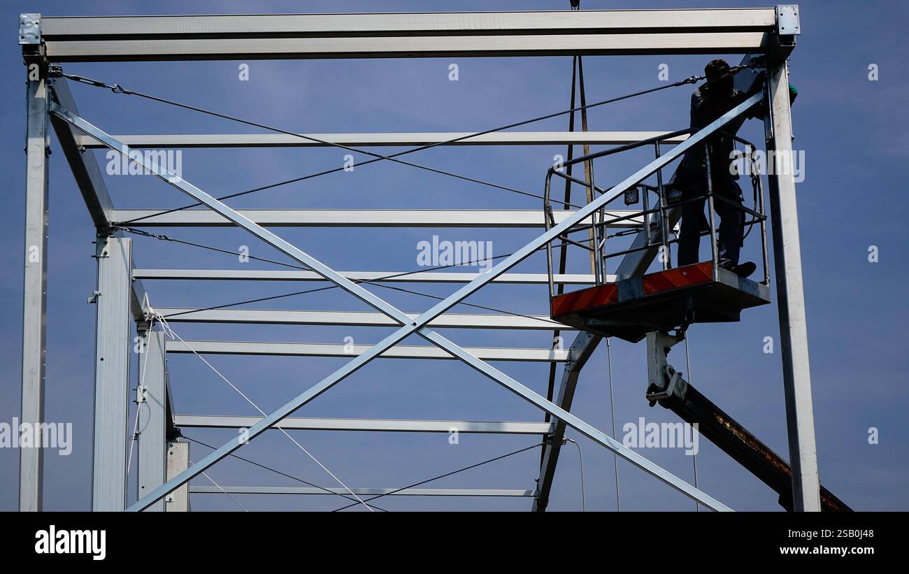 Man workers on a crane performs high-rise work on welding metal ...