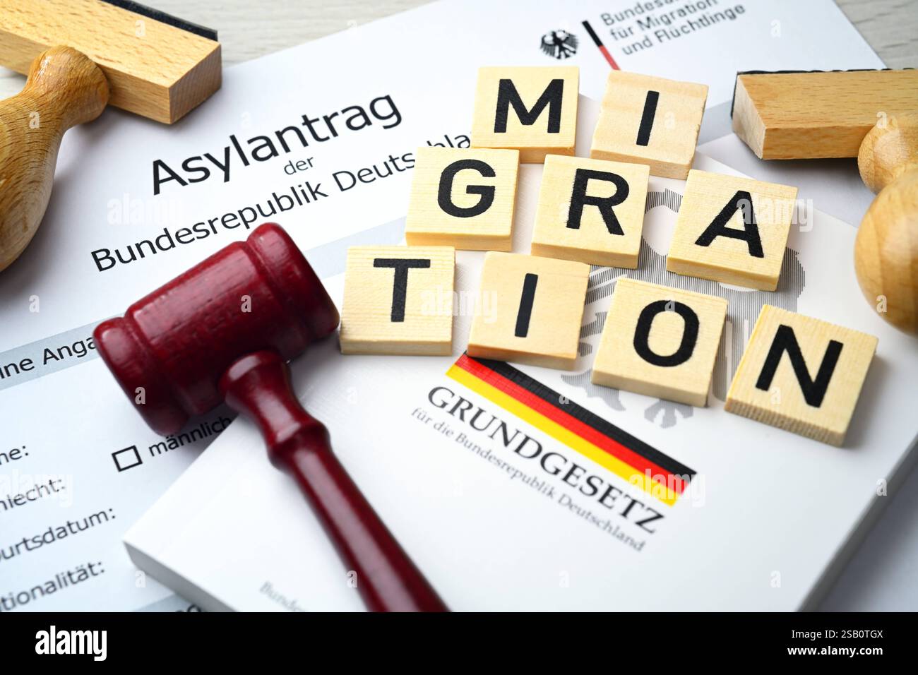 Schriftzug Migration und Richterhammer auf Grundgesetz und Asylantrag ...