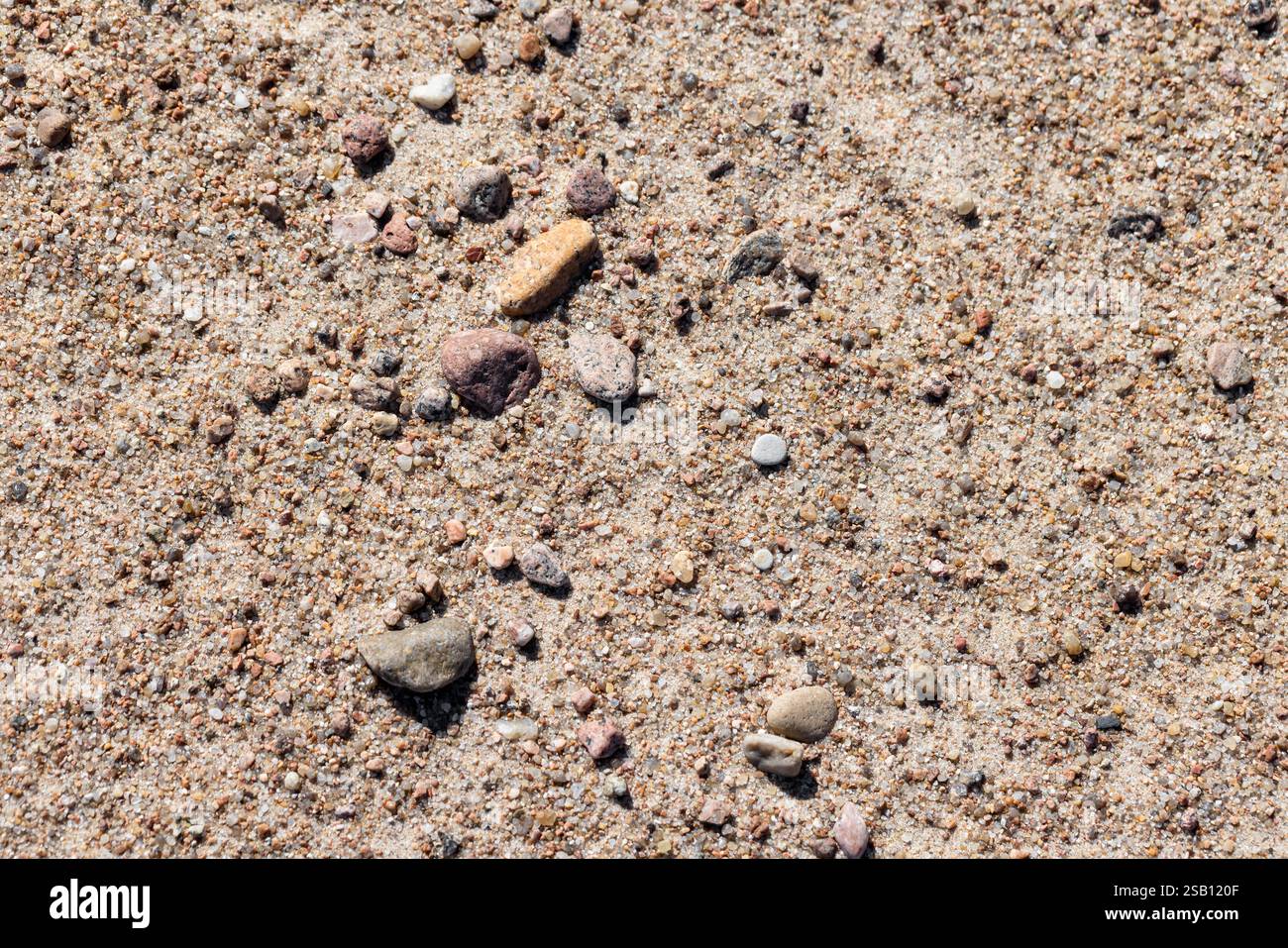 Small stones are in coastal sand on the shore of the Baltic Sea, top ...