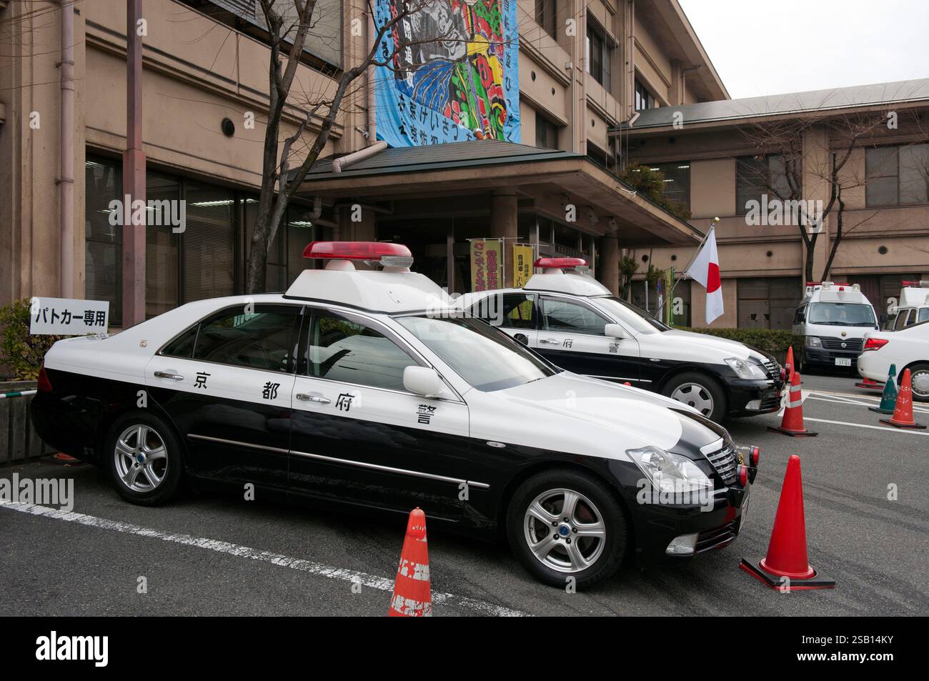 Black and White Japanese police patrol car parked in a parking lot beside a police station in ...