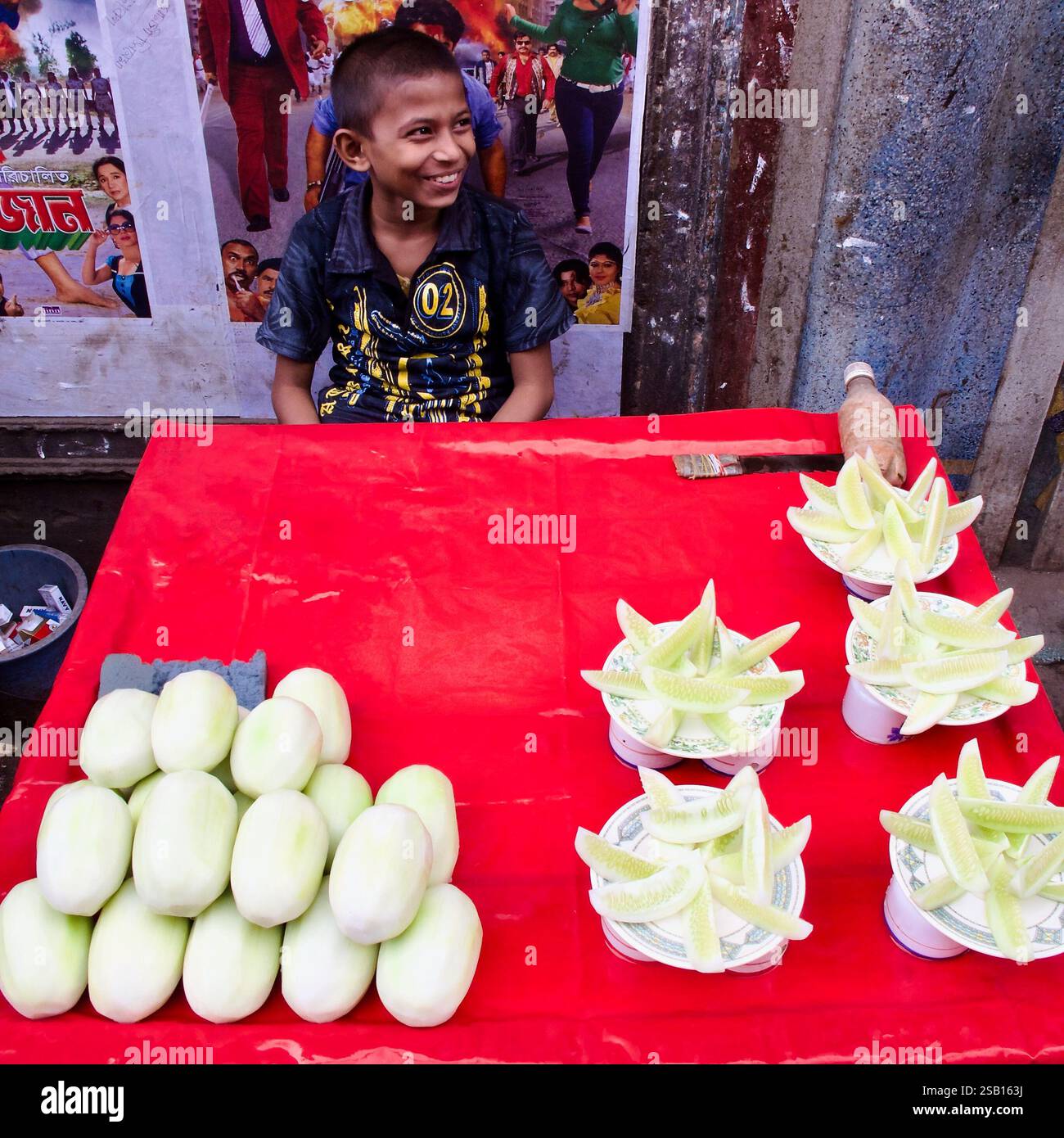 A young vendor selling sliced cucumbers at a street stall in Chawk ...