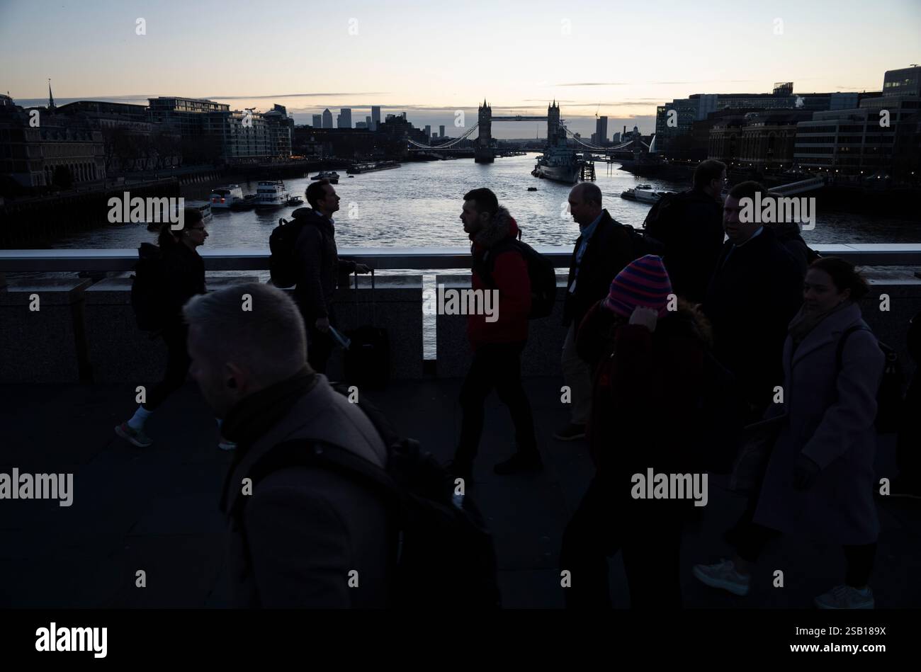 City workers walk across London Bridge, in the financial district of ...