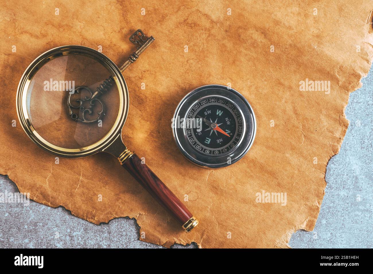 Compass, magnifying glass and key on background grunge paper Stock ...