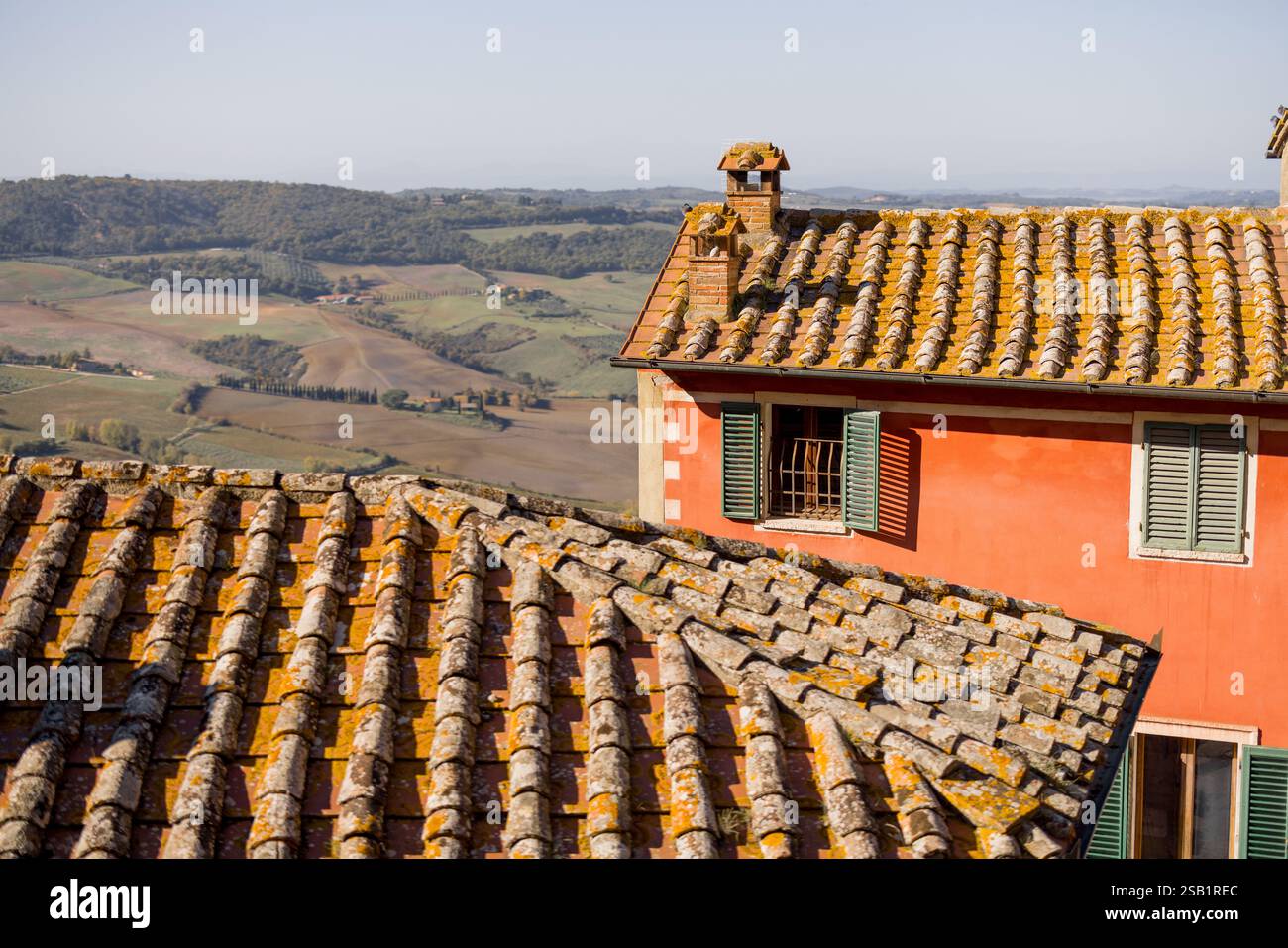 Traditional Tuscan rooftops with vibrant tiles overlooking rolling ...