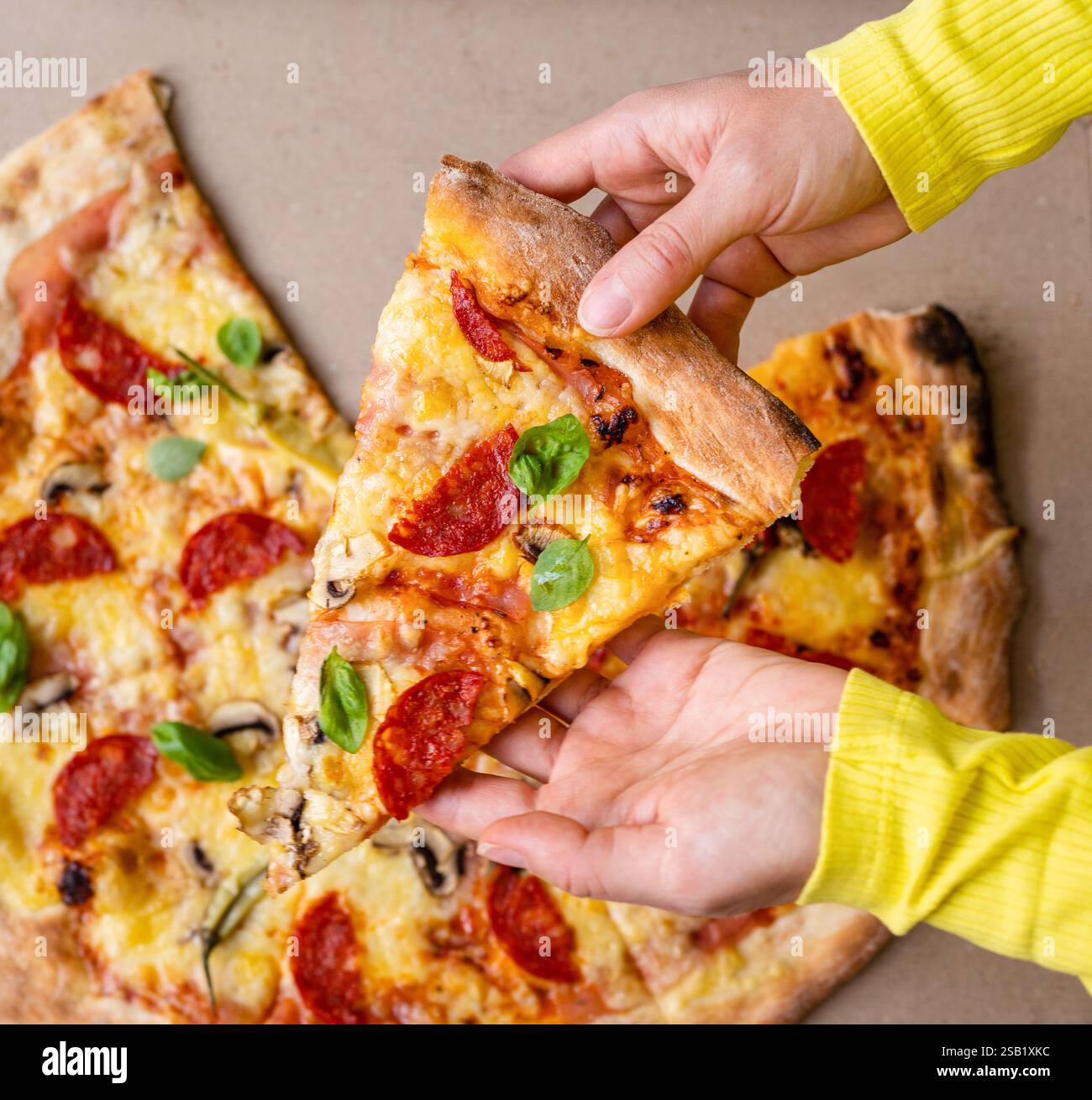 Slice of pizza in female hands top view photo Stock Photo - Alamy