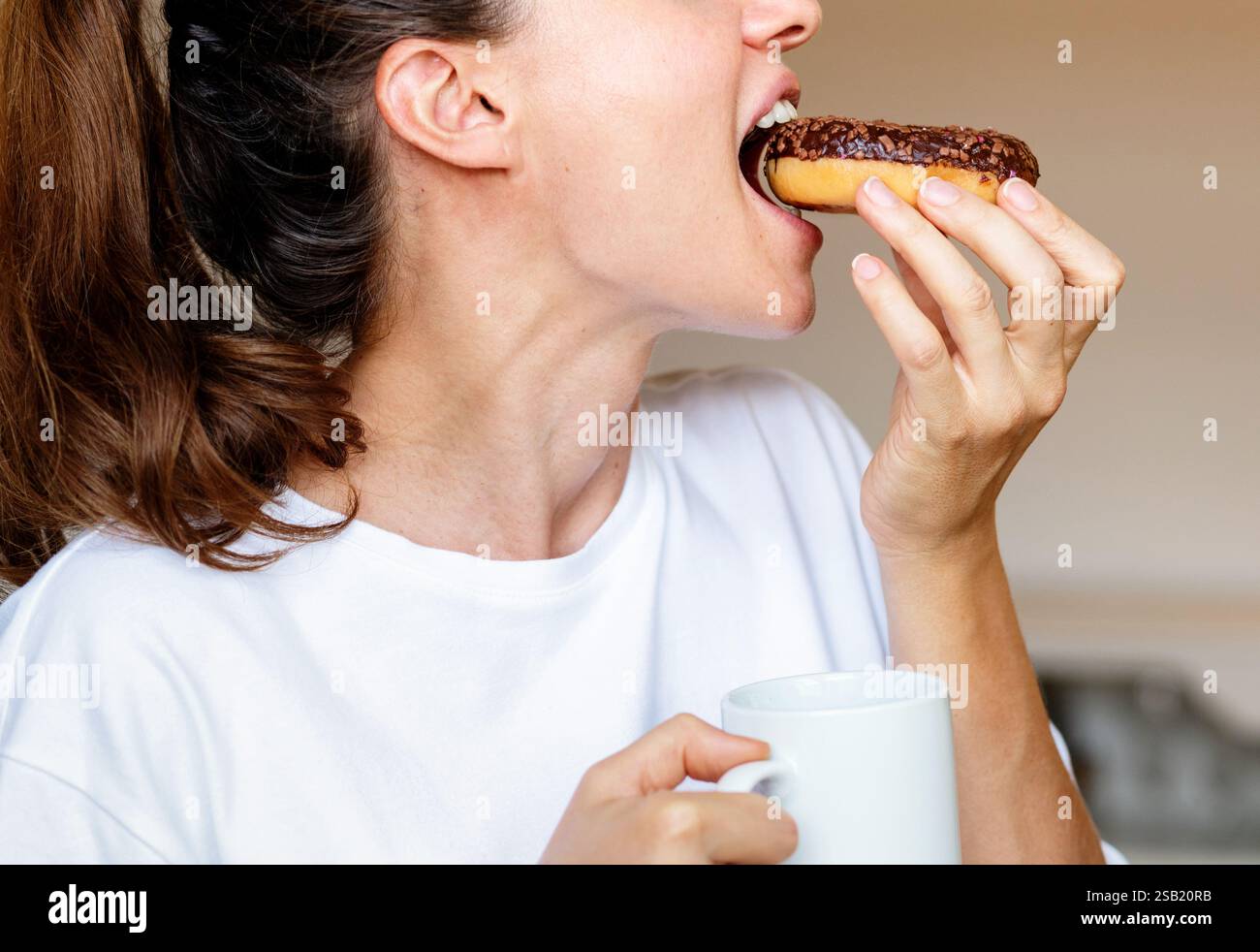 Side view closeup photo of young woman eating chocolate donut Stock ...