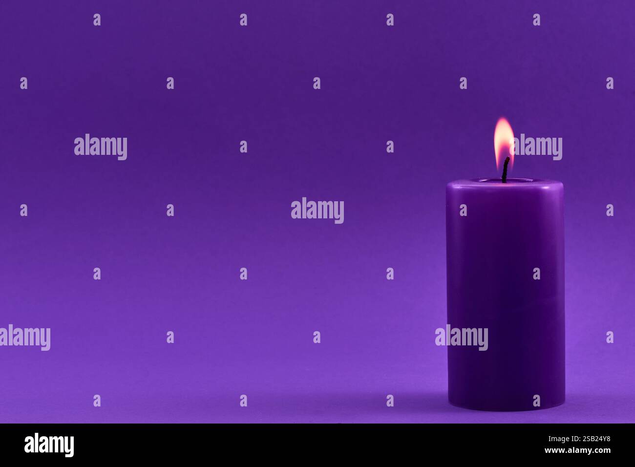 Purple Candle. A single purple candle burning with a soft flame Stock ...