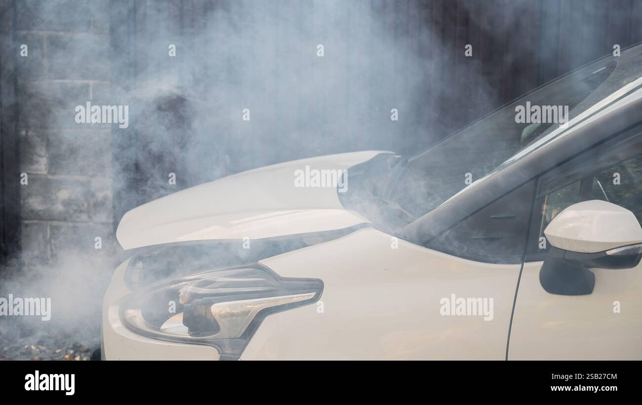 Smoke is coming from under the hood of the car Stock Photo - Alamy