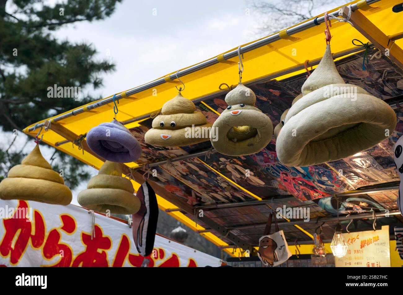 Funny children's poop toys hanging from a festival street stall at a ...