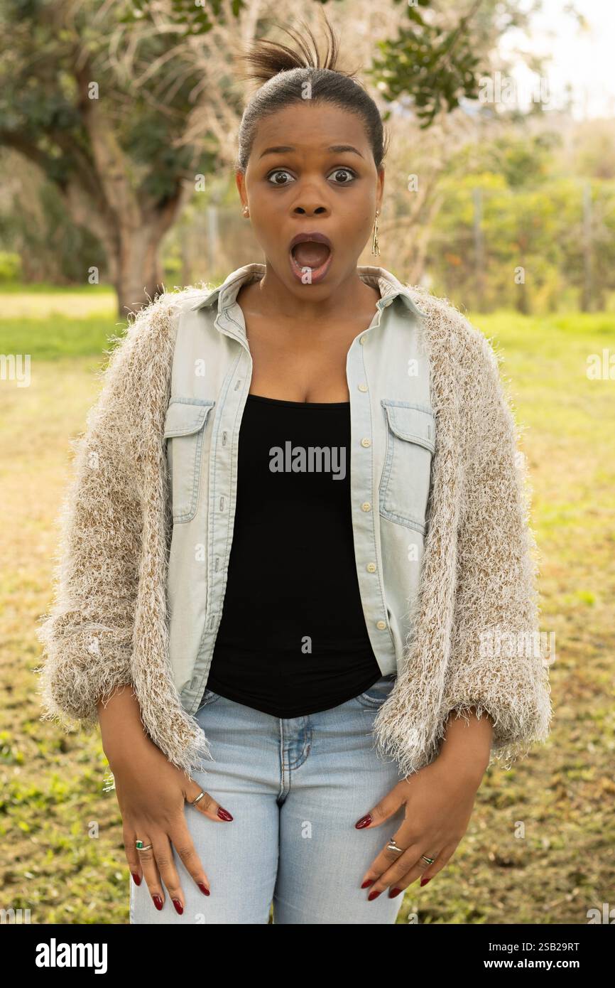 A black woman displays a surprised and shocked expression with her ...