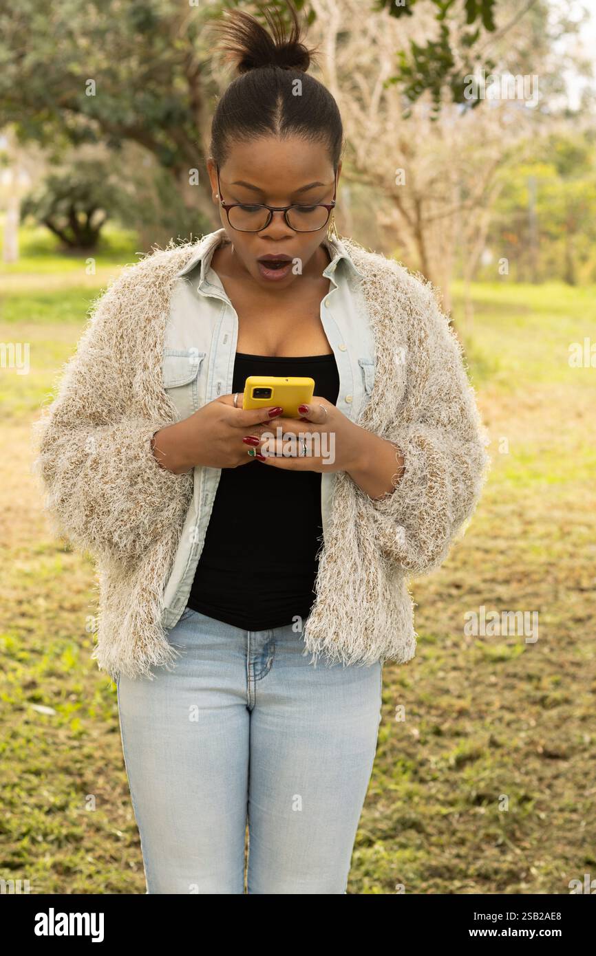 A black woman wearing glasses and a cozy outfit shows surprise and ...