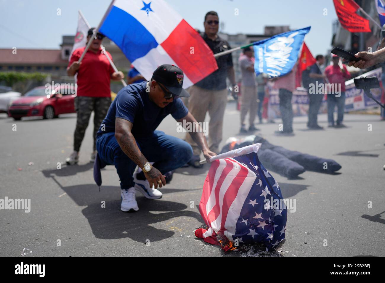A demonstrator burns a U.S. flag to protest the upcoming visit of U.S ...