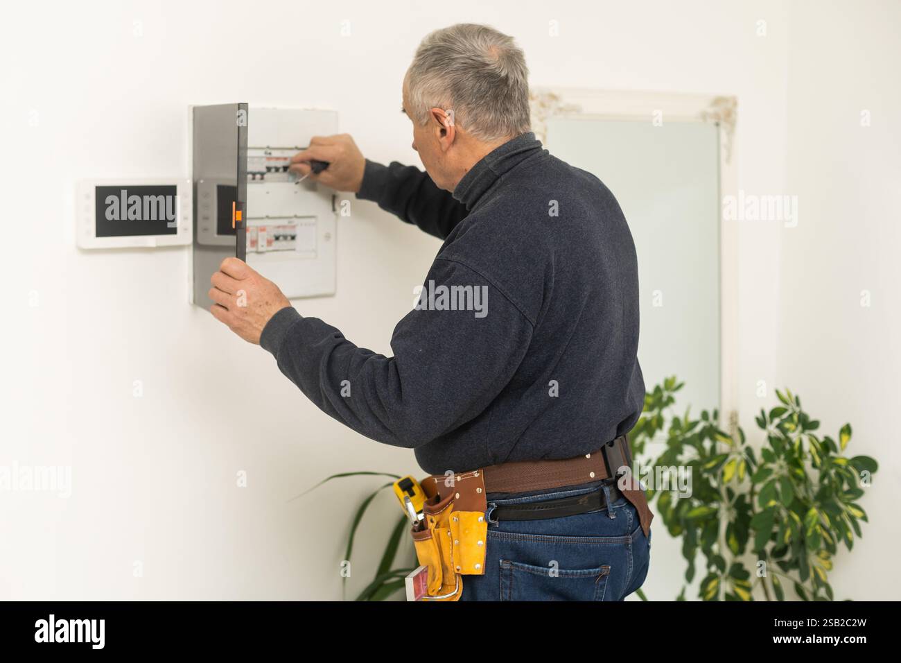 Elder man fixing an electric meter Stock Photo - Alamy