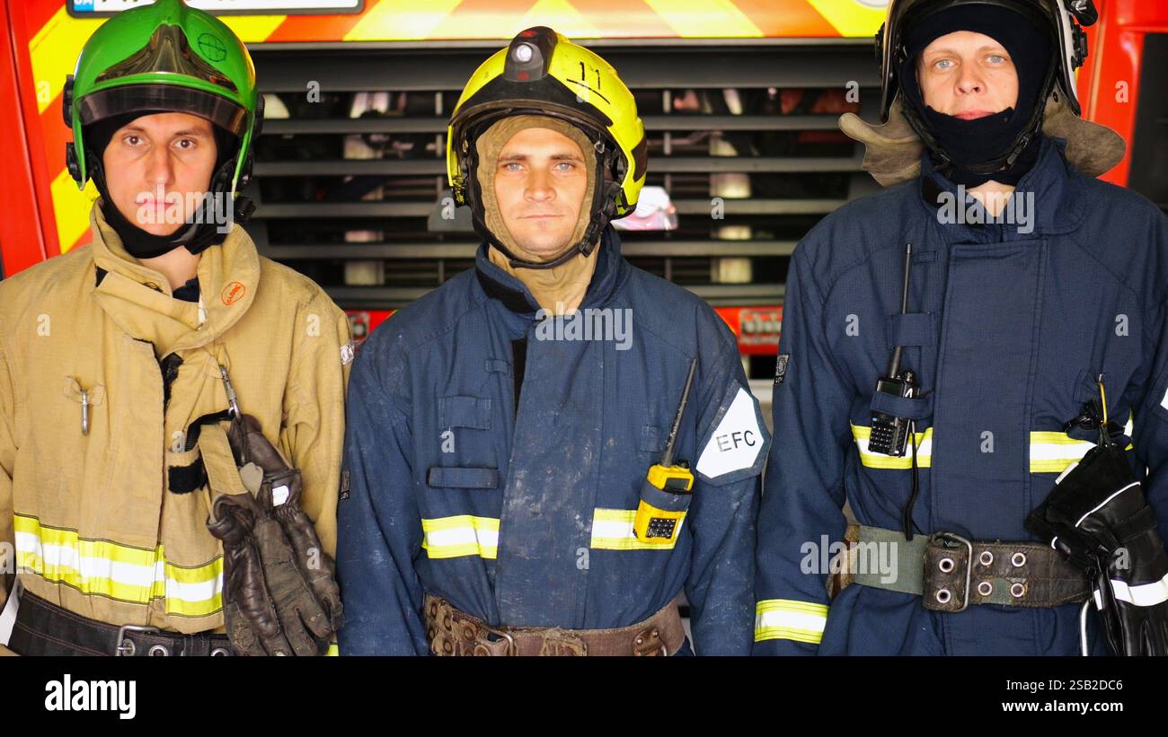 Portrait of male firefighters in helmets and protective uniforms ...