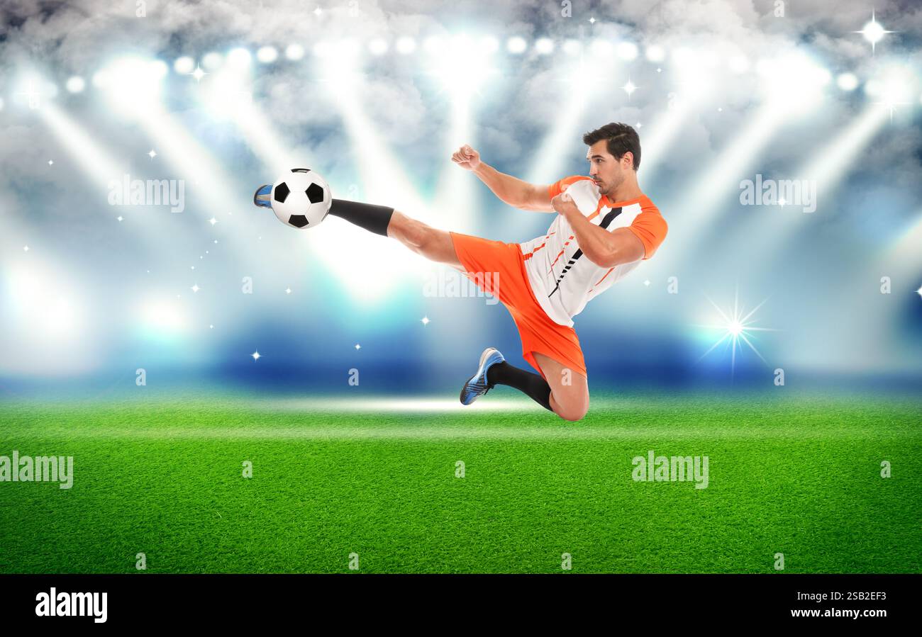 Young man playing football under lights at stadium Stock Photo - Alamy