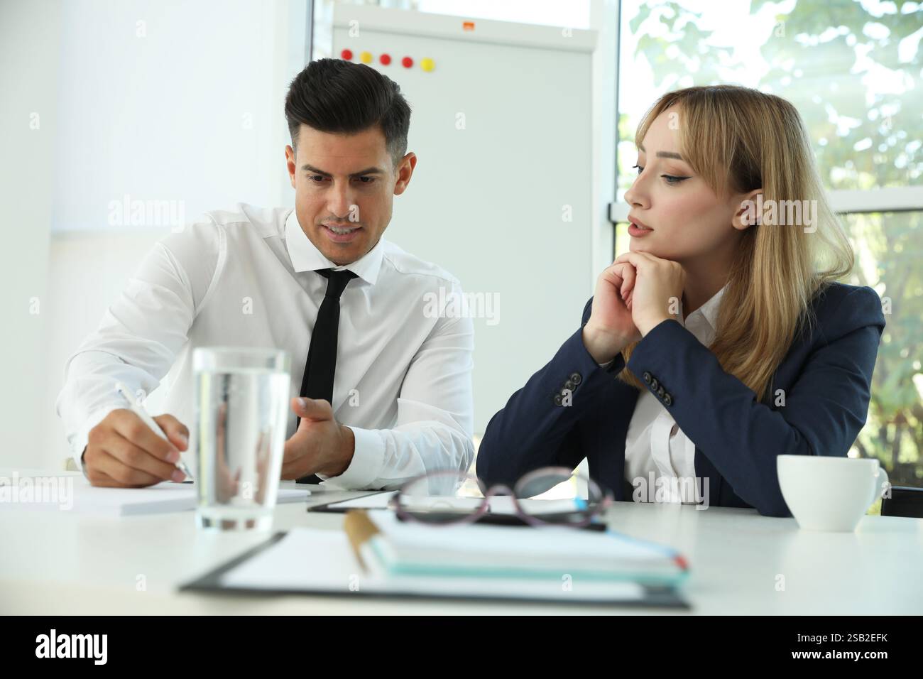 Office employees talking at table during meeting Stock Photo - Alamy