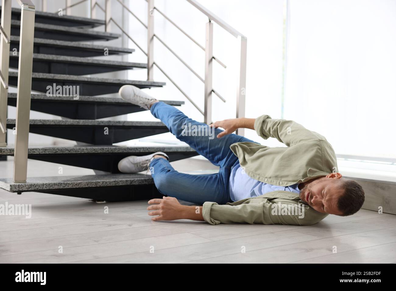 Injured man on floor in building after fall from stairs. Dangerous ...