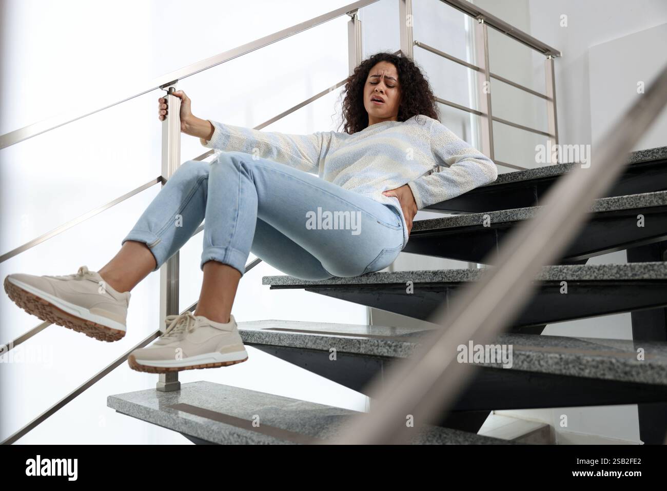 Injured woman on stairs in building after fall. Dangerous accident ...