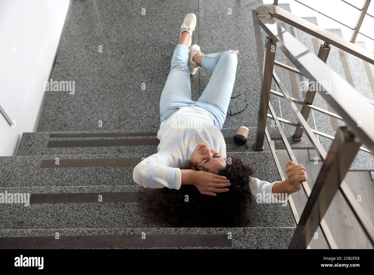 Woman with injured head on stairs in building after fall, above view ...