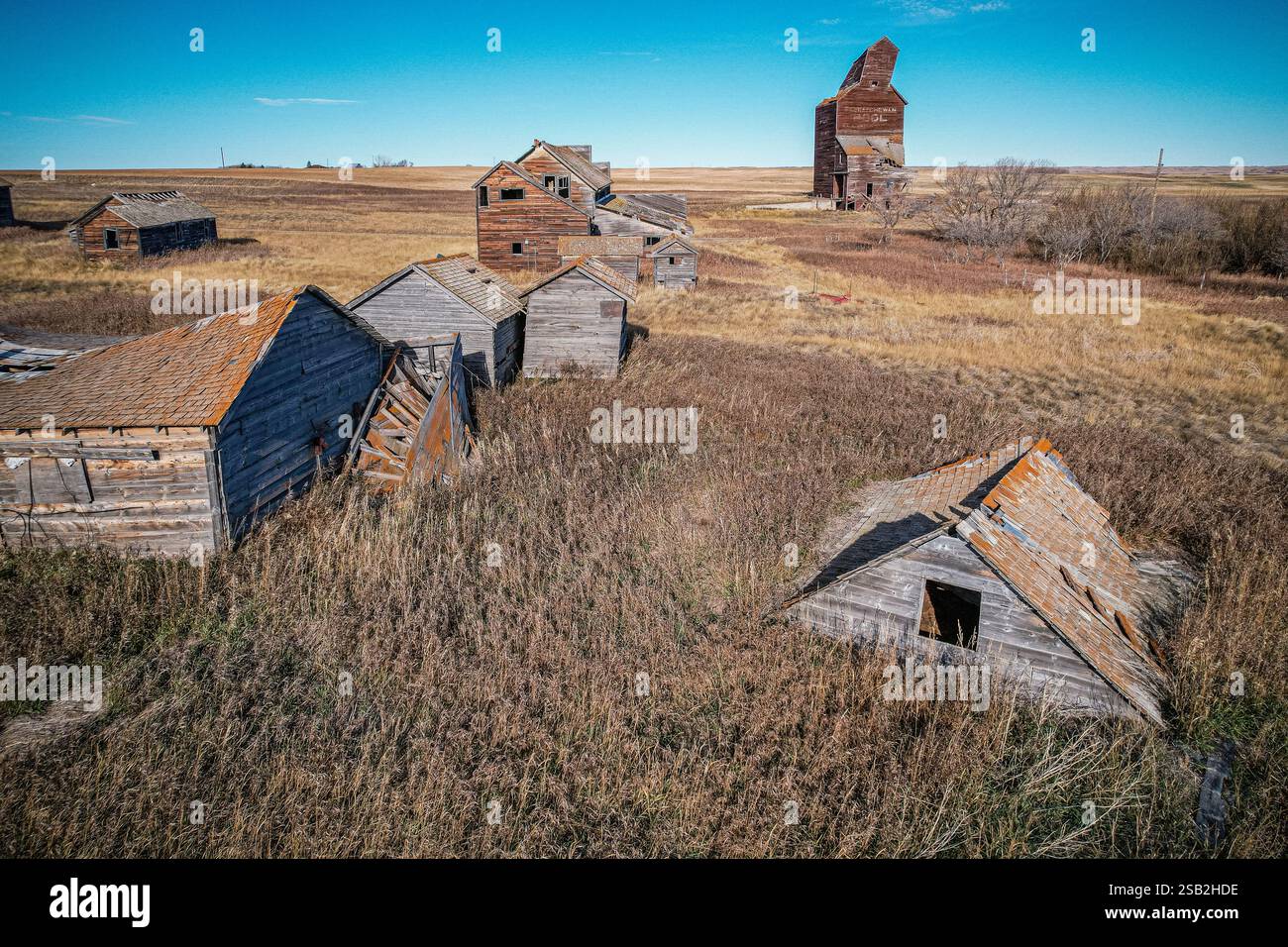 A group of old buildings are in a field. The buildings are in a field ...