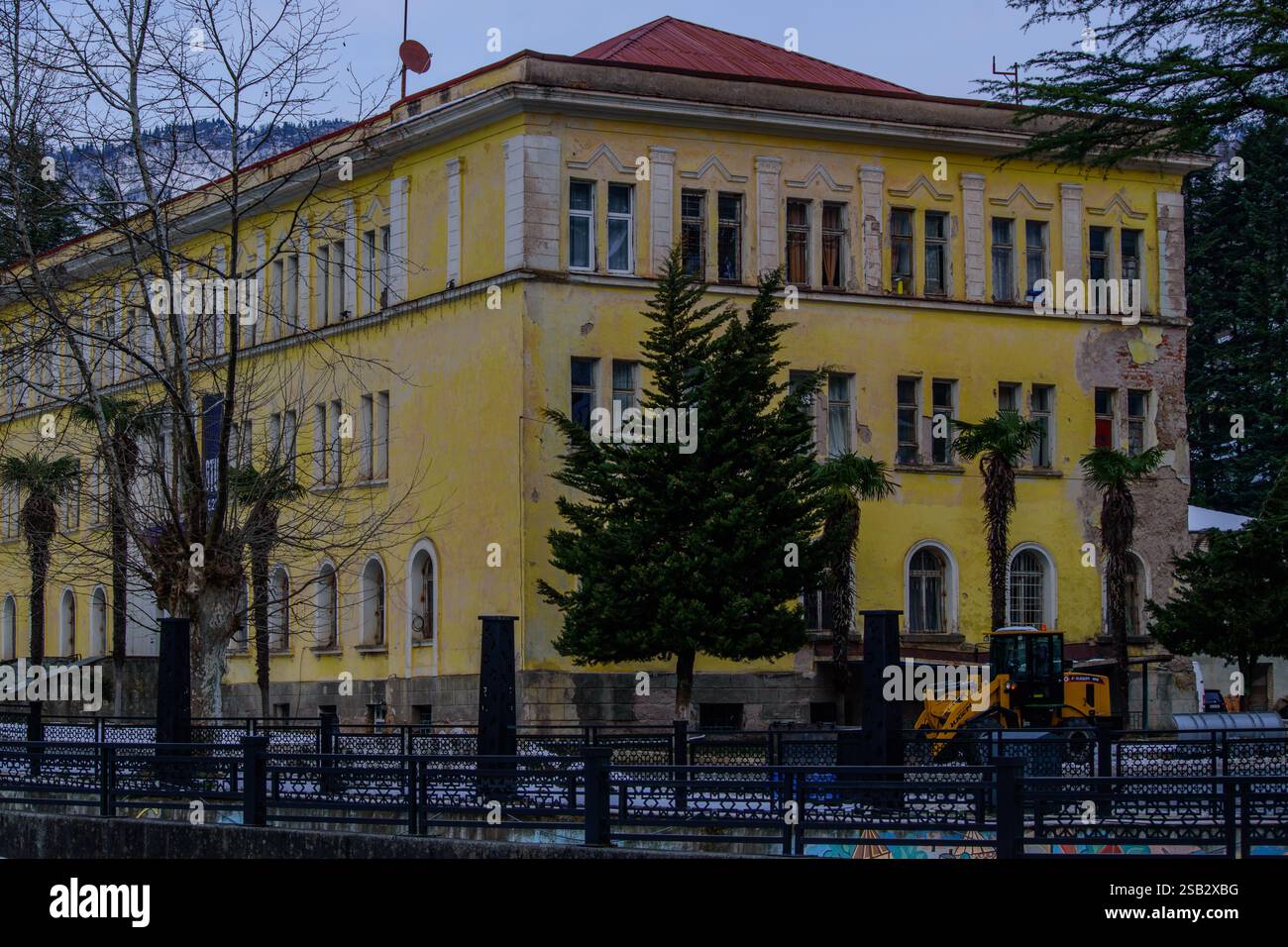 A large yellow building standing tall in the city, its vibrant color ...