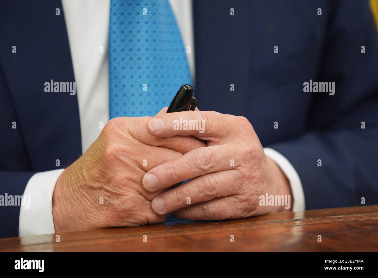 President Donald Trump holds a pen as he talks while signing executive ...