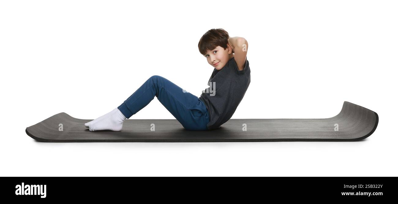 Boy exercising on fitness mat against white background. Sport activity ...