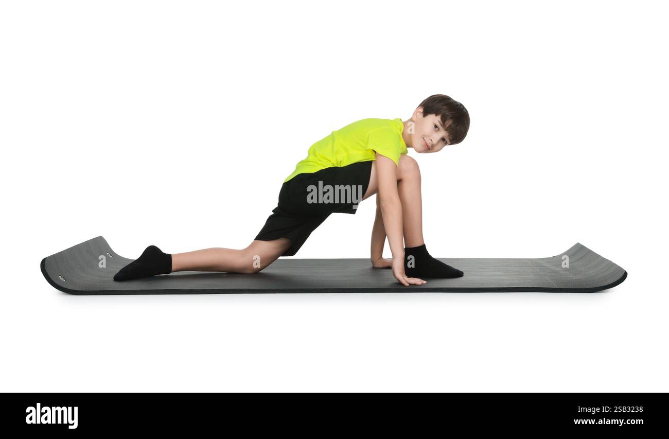 Boy exercising on fitness mat against white background. Sport activity ...