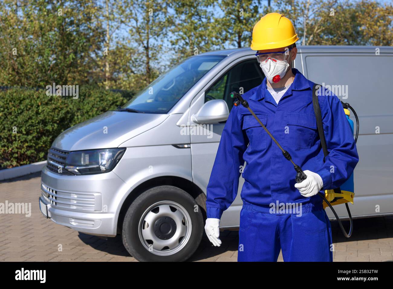 Pest control worker with spray tank outdoors Stock Photo - Alamy