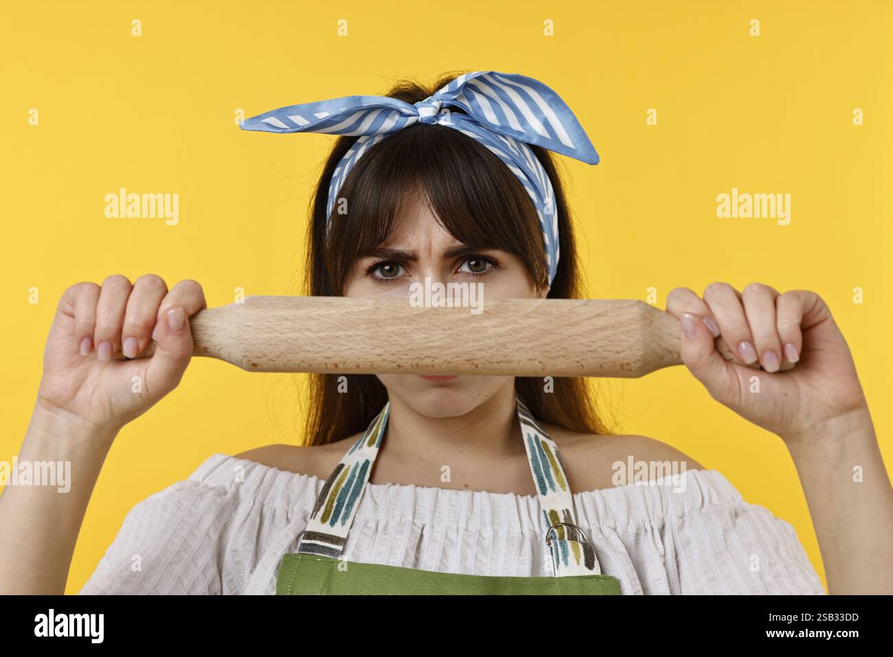 Angry woman with rolling pin on yellow background Stock Photo - Alamy