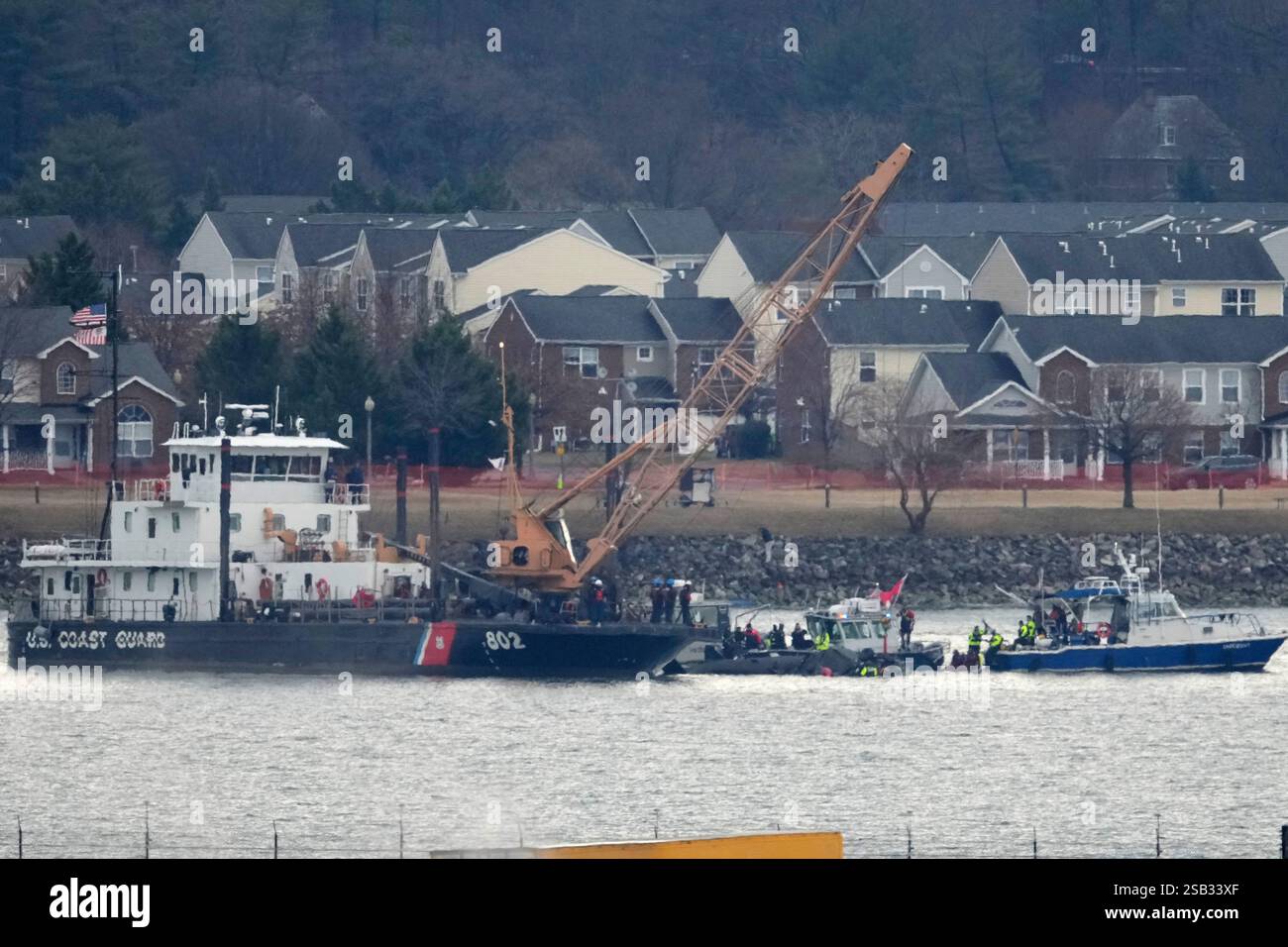 A Coast Guard vessel with a crane is pictured as it works near the ...