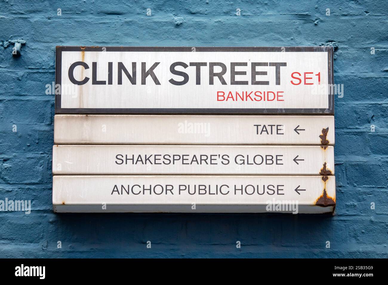 A street sign for Clink Street in London, UK. Below it are signposts ...