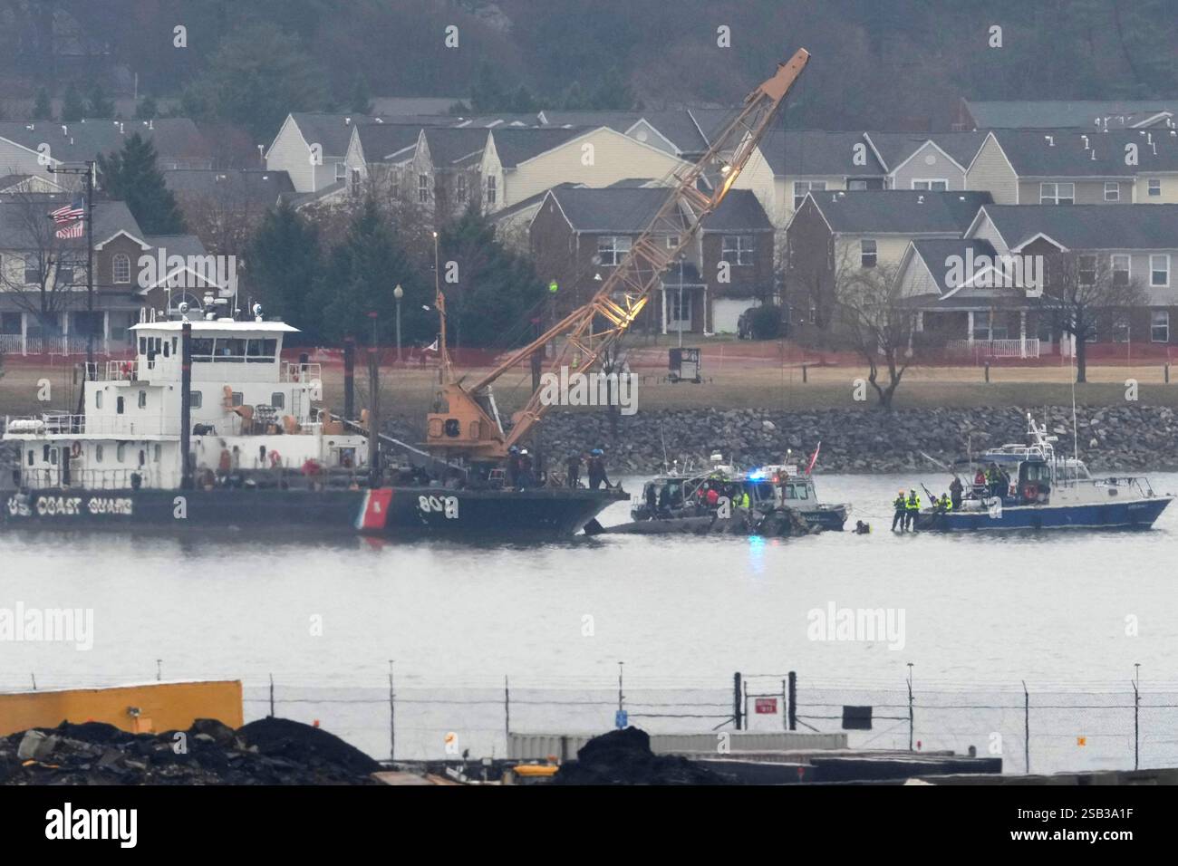 A member of a dive team and a Coast Guard vessel with a crane are ...
