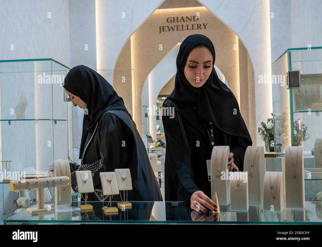 DOHA JEWELLERY AND WATCHES EXHIBITION Two women arrange at a Qatari ...