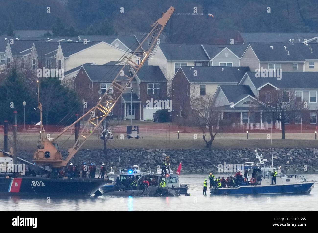A Coast Guard vessel with a crane is pictured as it works near the ...
