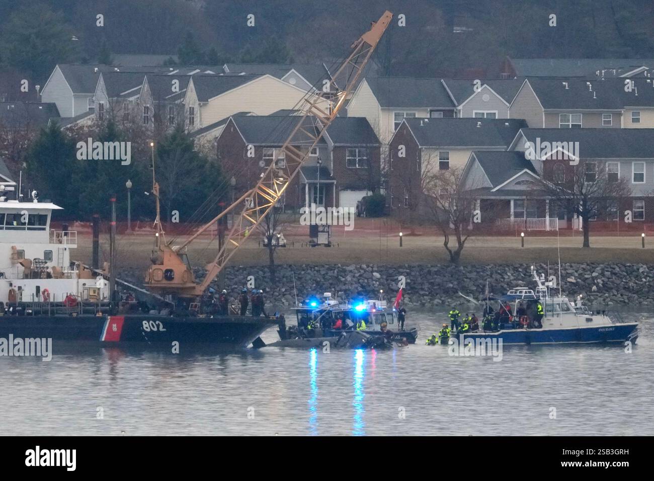 A Coast Guard vessel with a crane and members of a dive team are ...