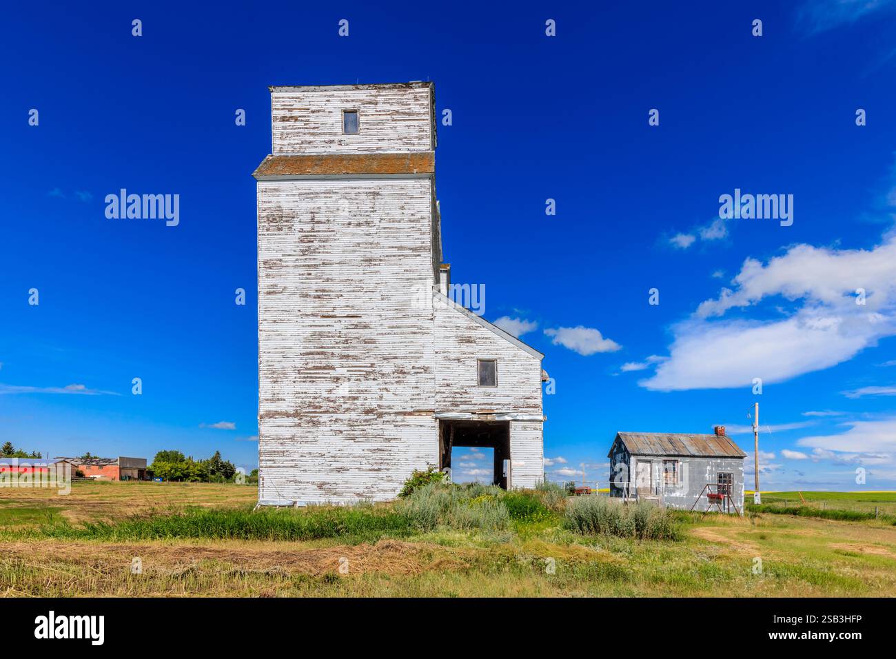 A large white building with a slanted roof. The building is surrounded ...