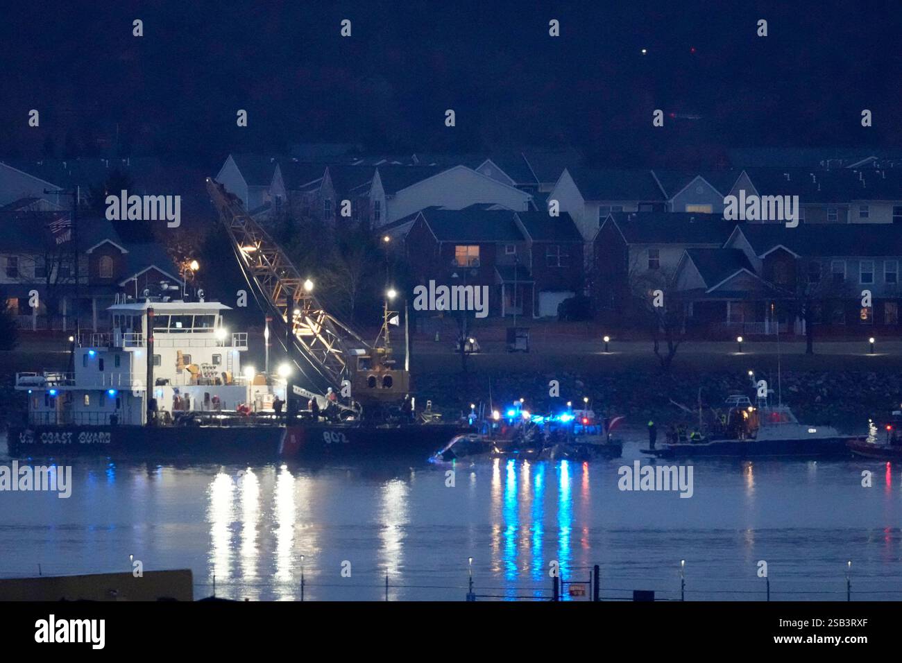 A Coast Guard vessel with a crane works near the wreckage of a Black ...