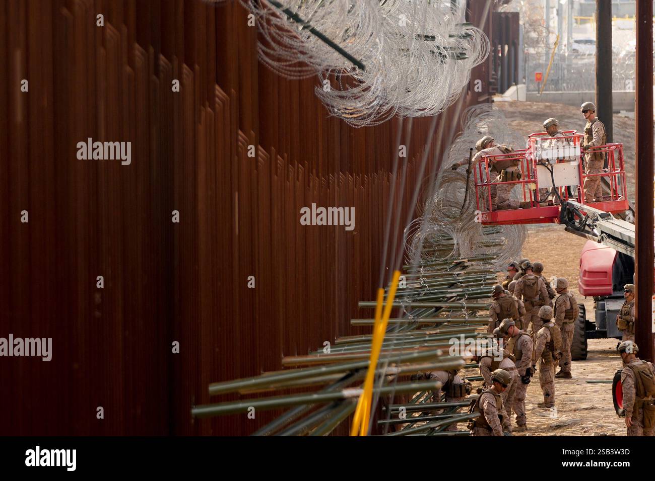 U.S. Marines install barbed wire along the border fence Friday, Jan. 31 ...