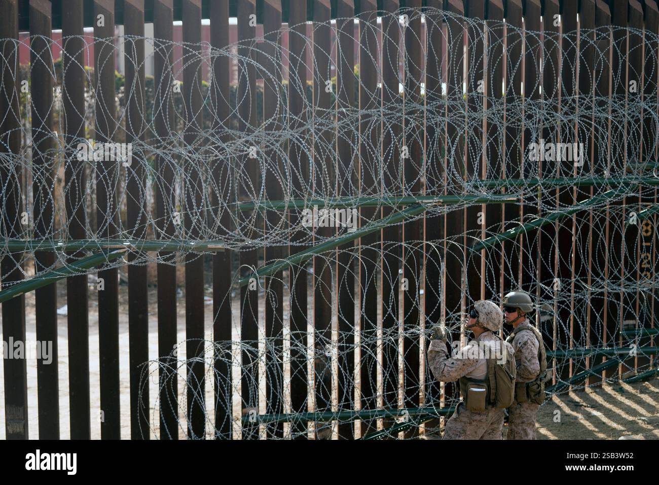 U.S. Marines install barbed wire along the border fence Friday, Jan. 31 ...